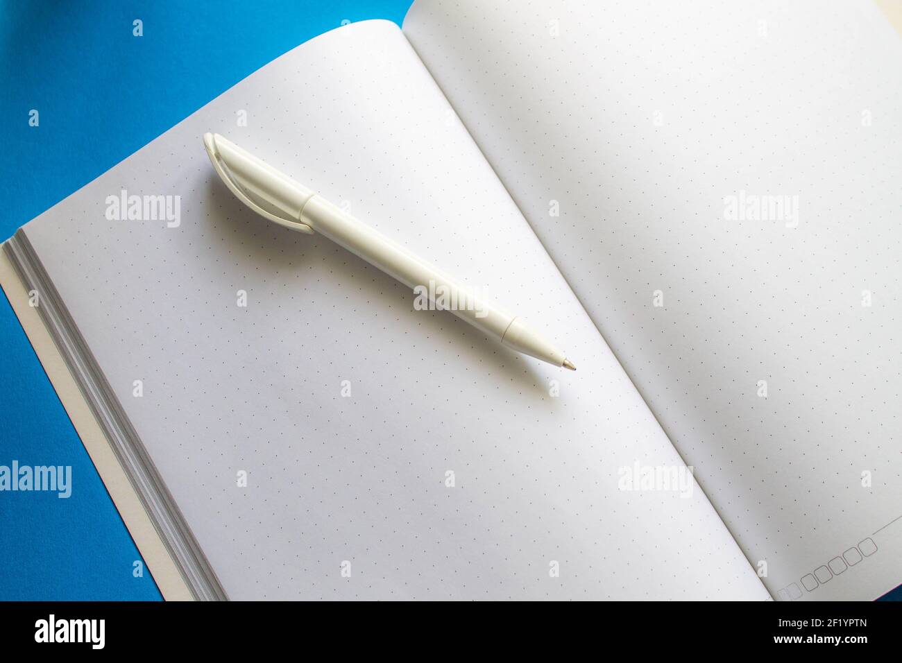 The pen rests on an unfolded notebook. Blank sheet and pen for writing ...