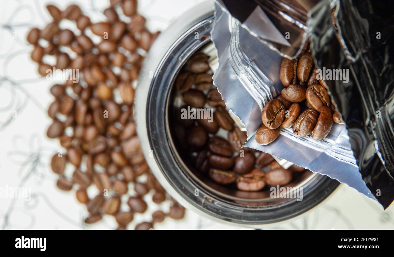A packet of coffee beans against the background of an electric coffee ...