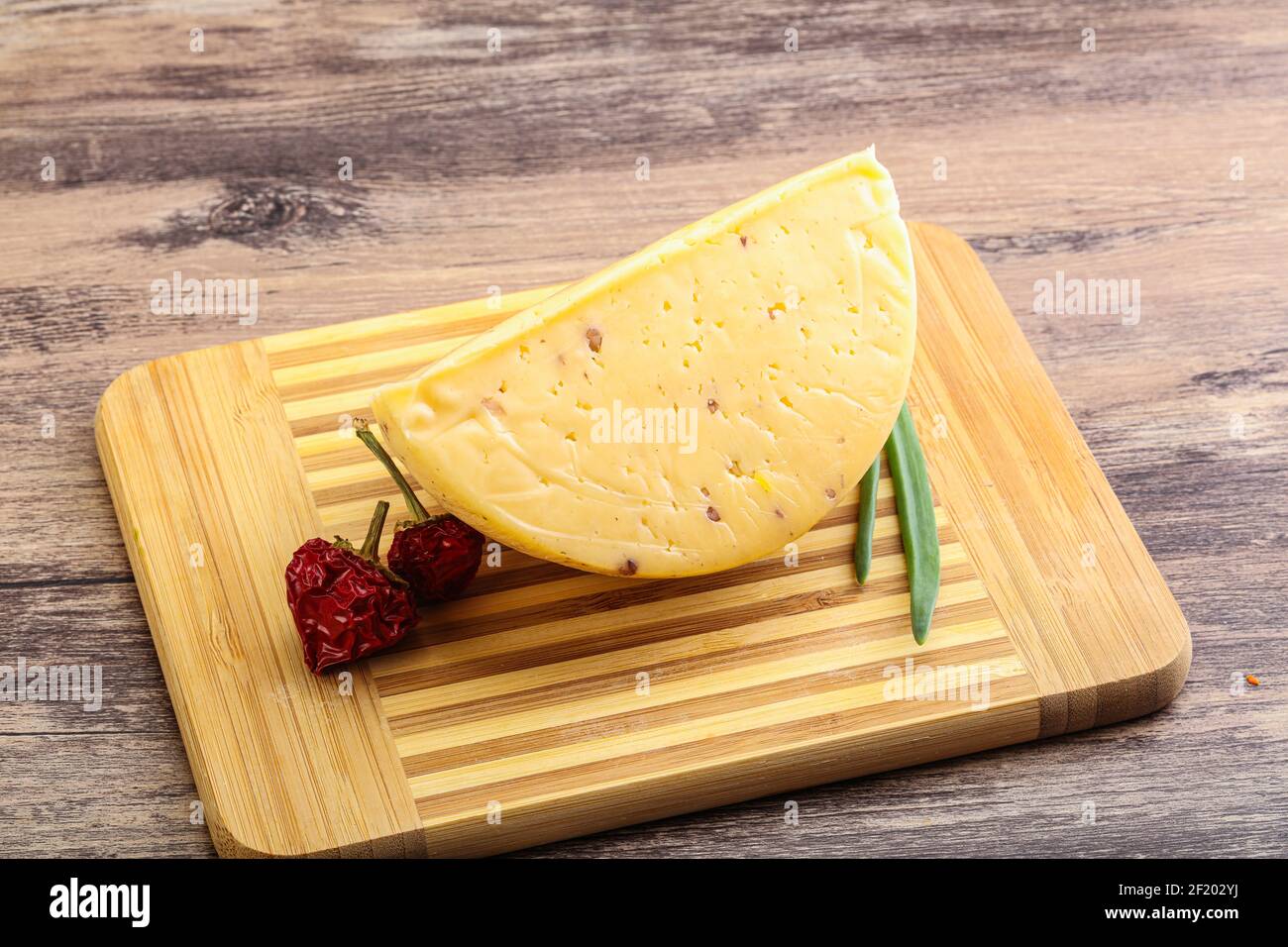 Hard cheese brick with walnut over board Stock Photo - Alamy