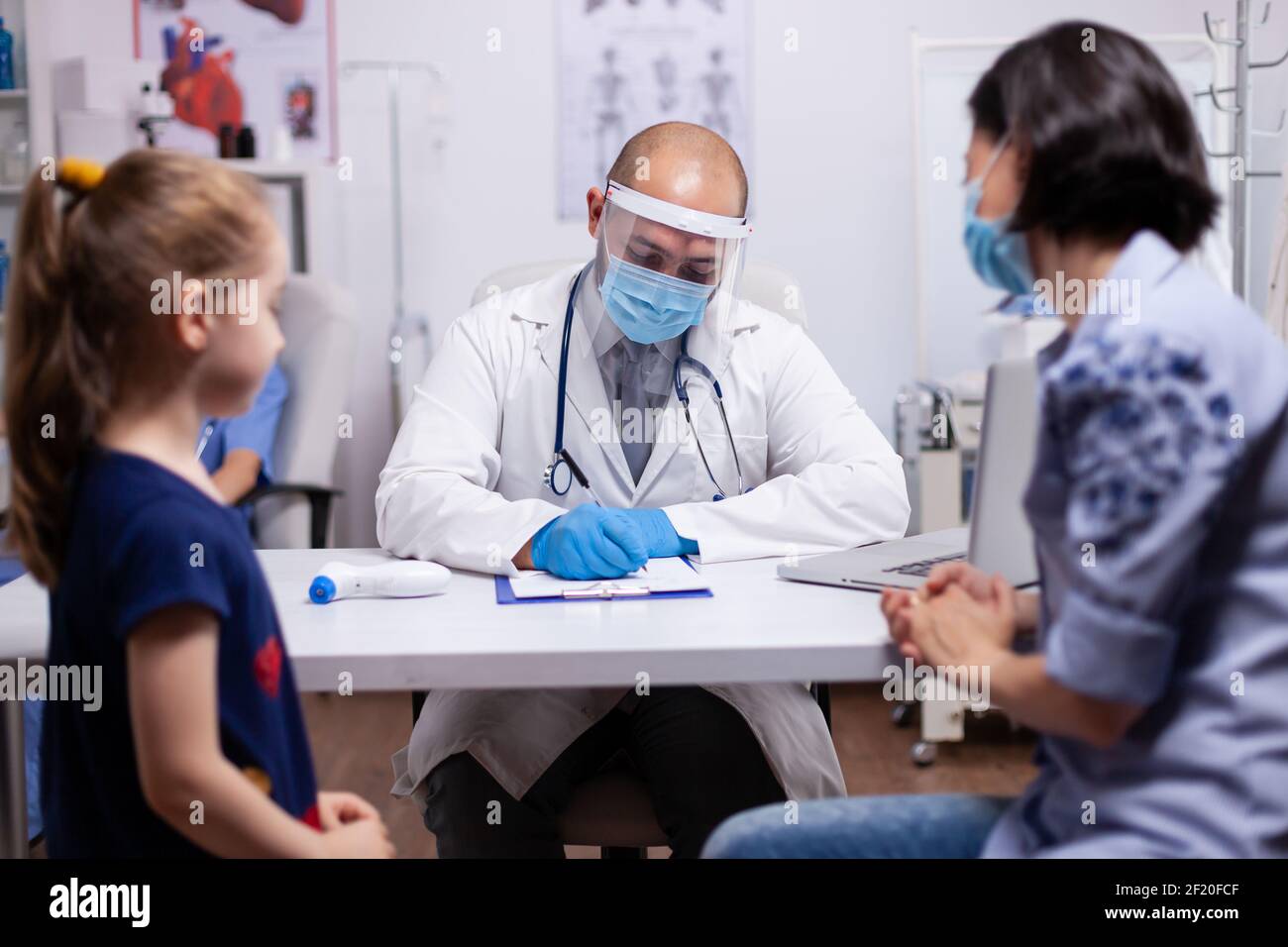 Pediatrician questioning patient about disease and writing answears in ...
