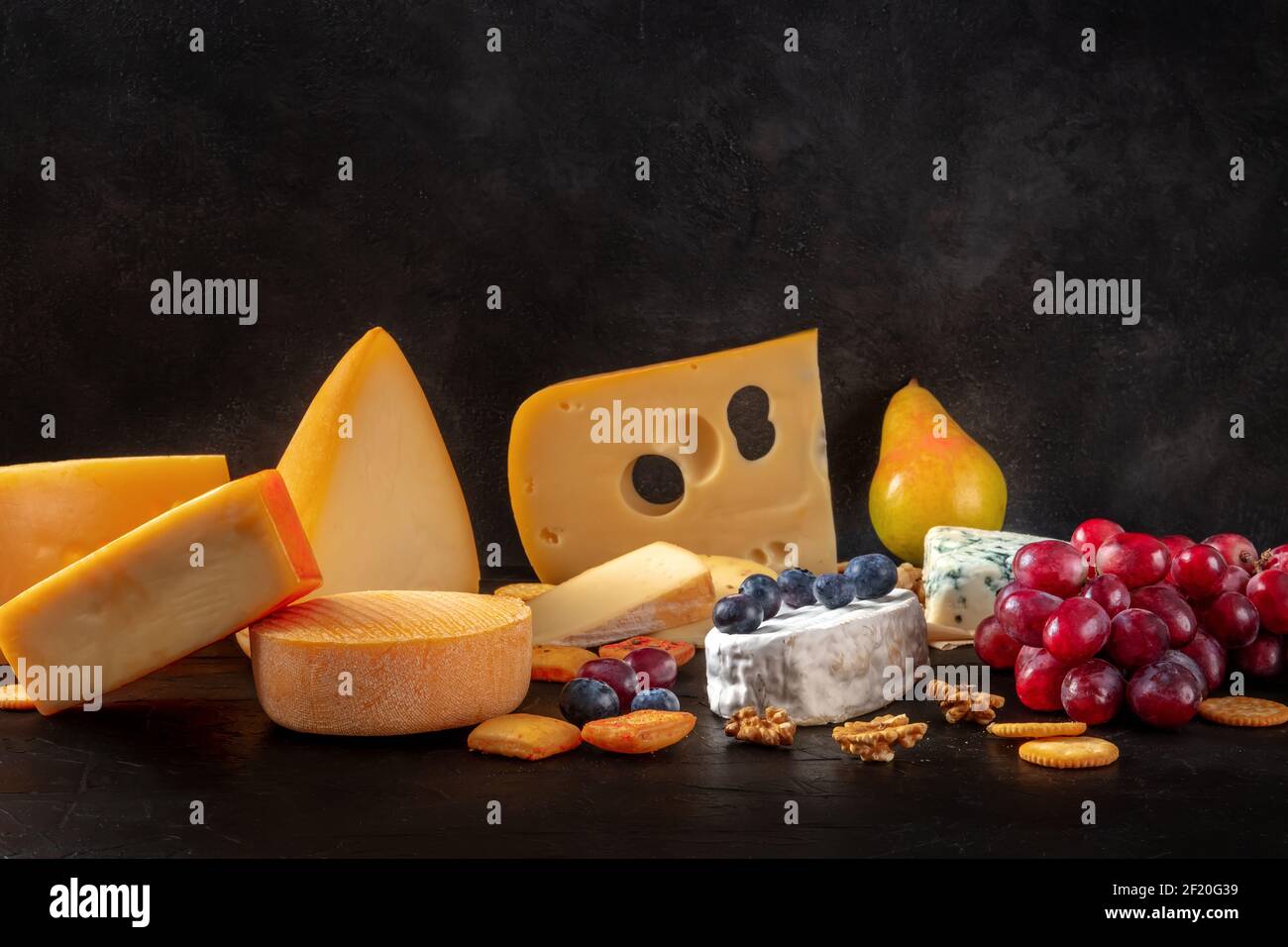 Cheese variety. Many different cheeses, a side view on a black ...