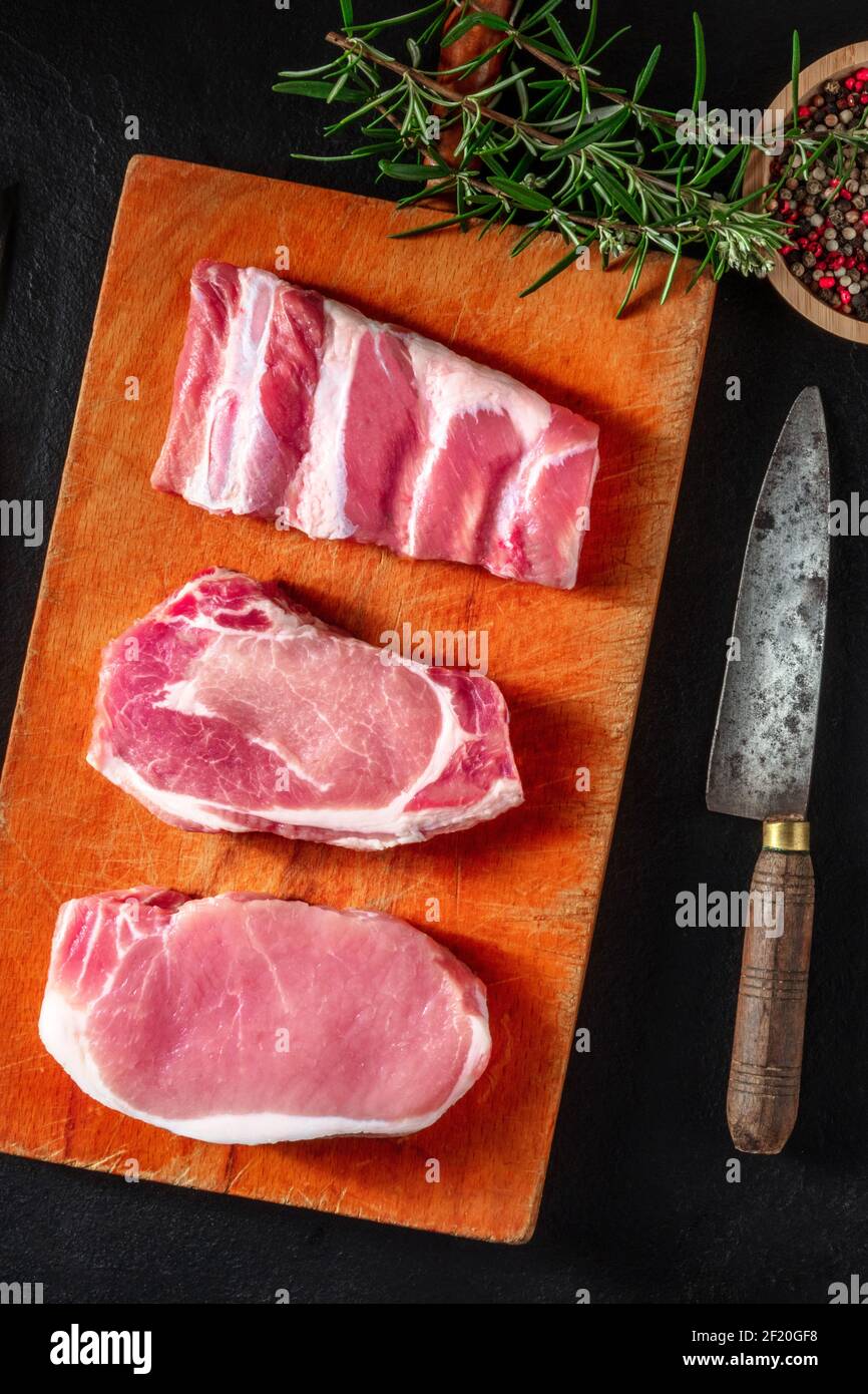 Pork meat types, different cuts, top shot on a black background with ...