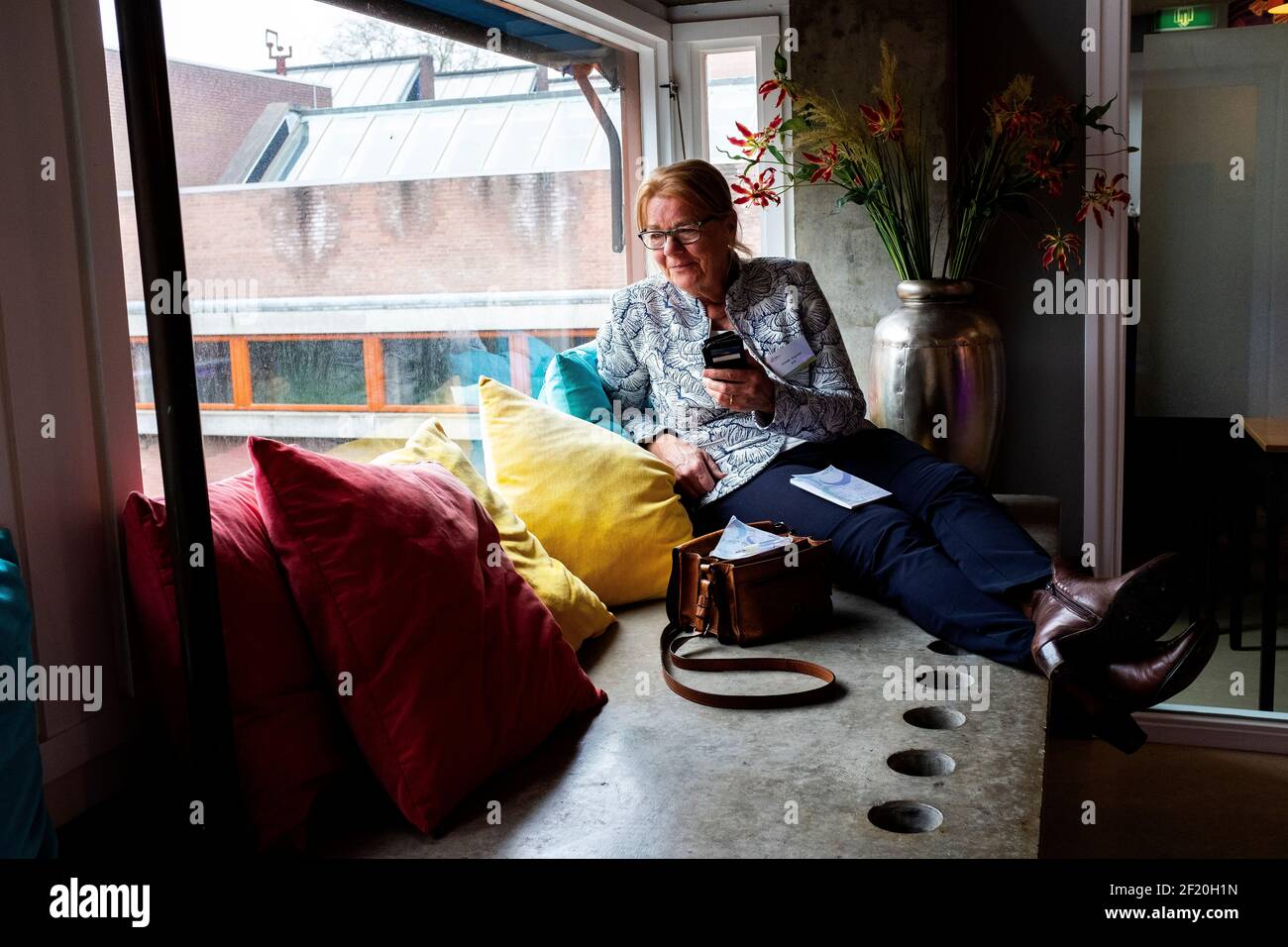 Nijmegen, Netherlands. Mature adult caucasian woman sitting on pilows ...