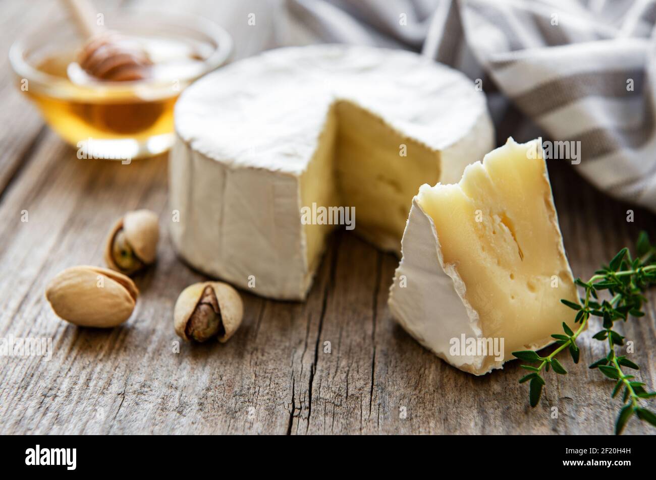 Camembert cheese, and snacks on old wooden table Stock Photo - Alamy