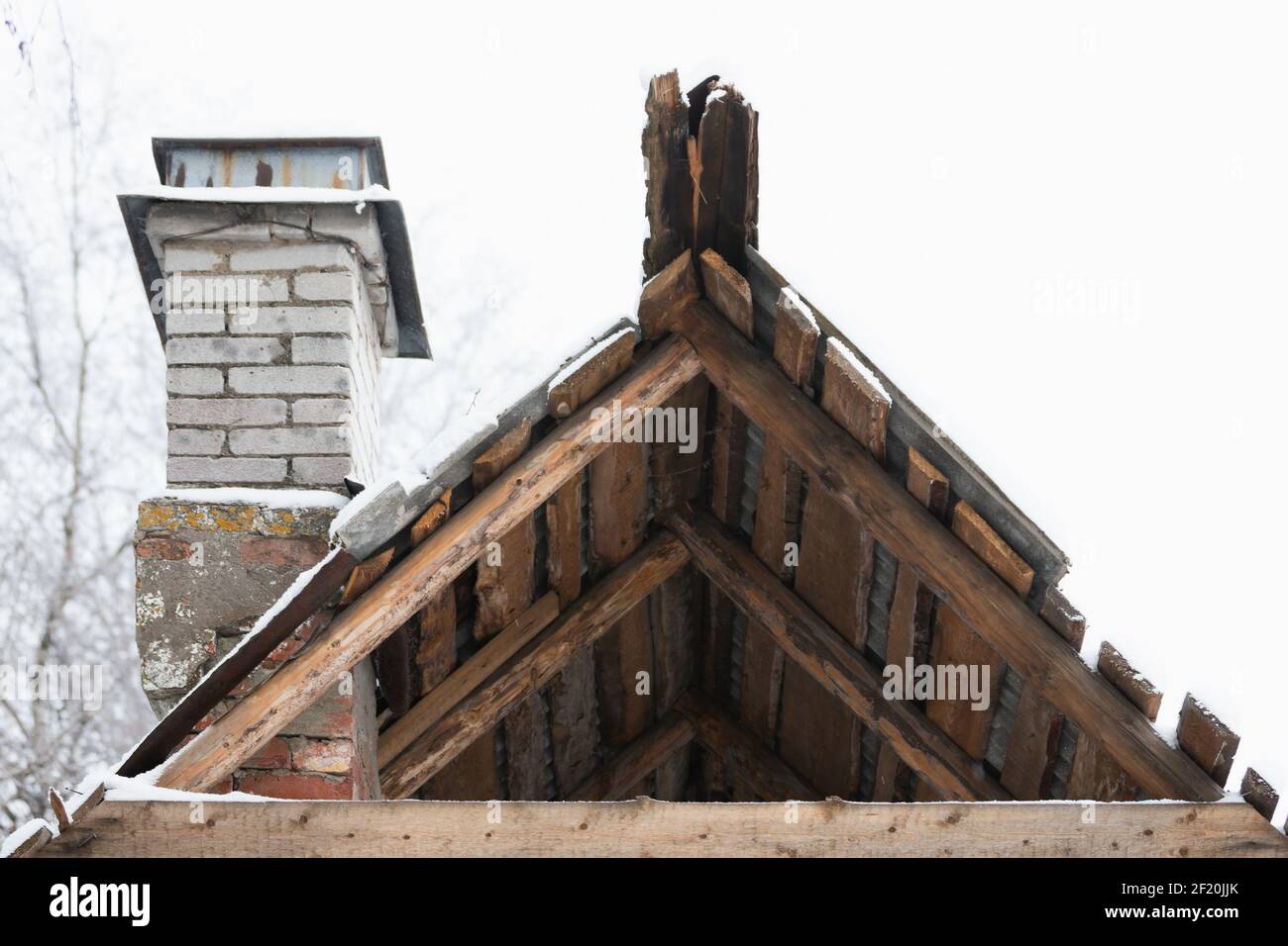 Old abandoned wooden house fragment, rooftop and chimney made of white ...