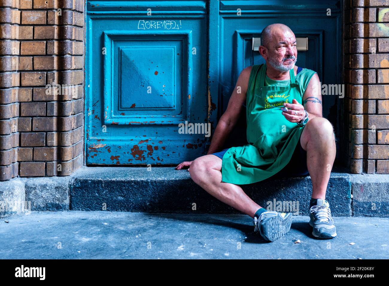 Berlin, Germany. Marketman taking a break smoking his cigarette outside ...