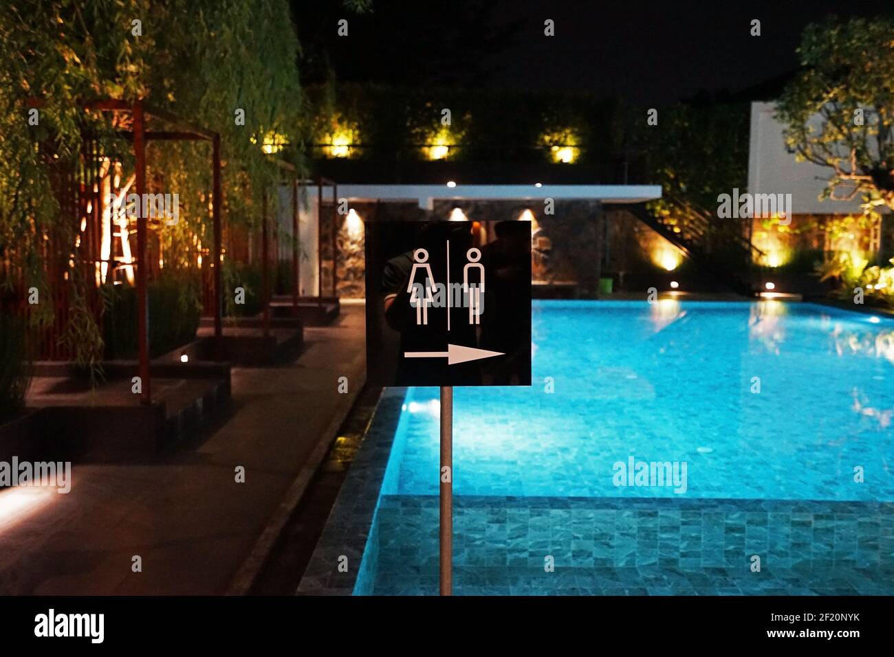 WC restroom signboard in front of the public swimming pool at night ...