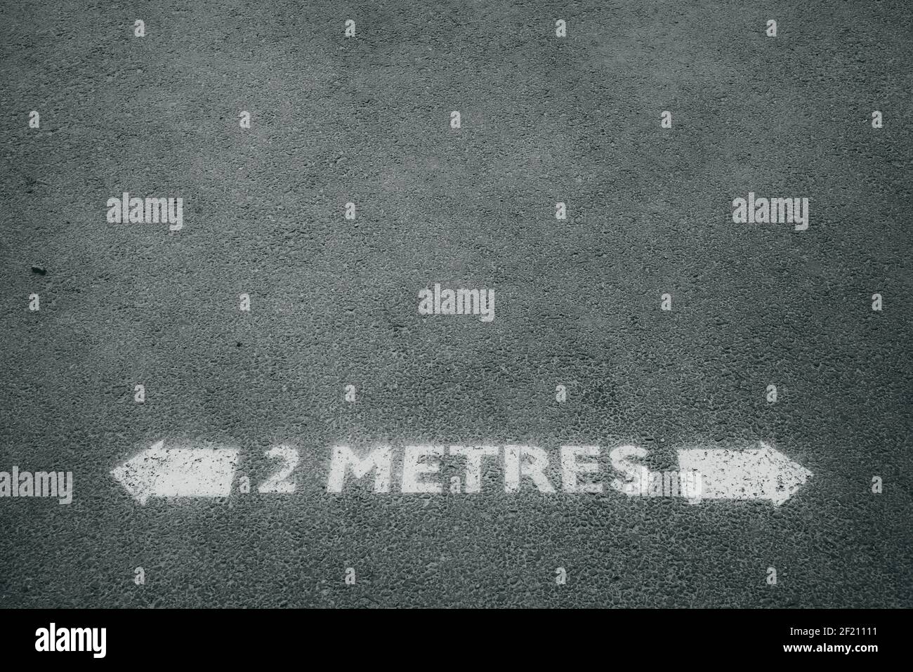 Social distancing road painted sign recommending staying 2 metres apart ...