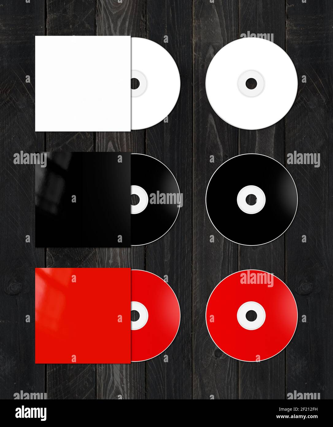 white, black and red CD - DVD and covers isolated on black wood ...