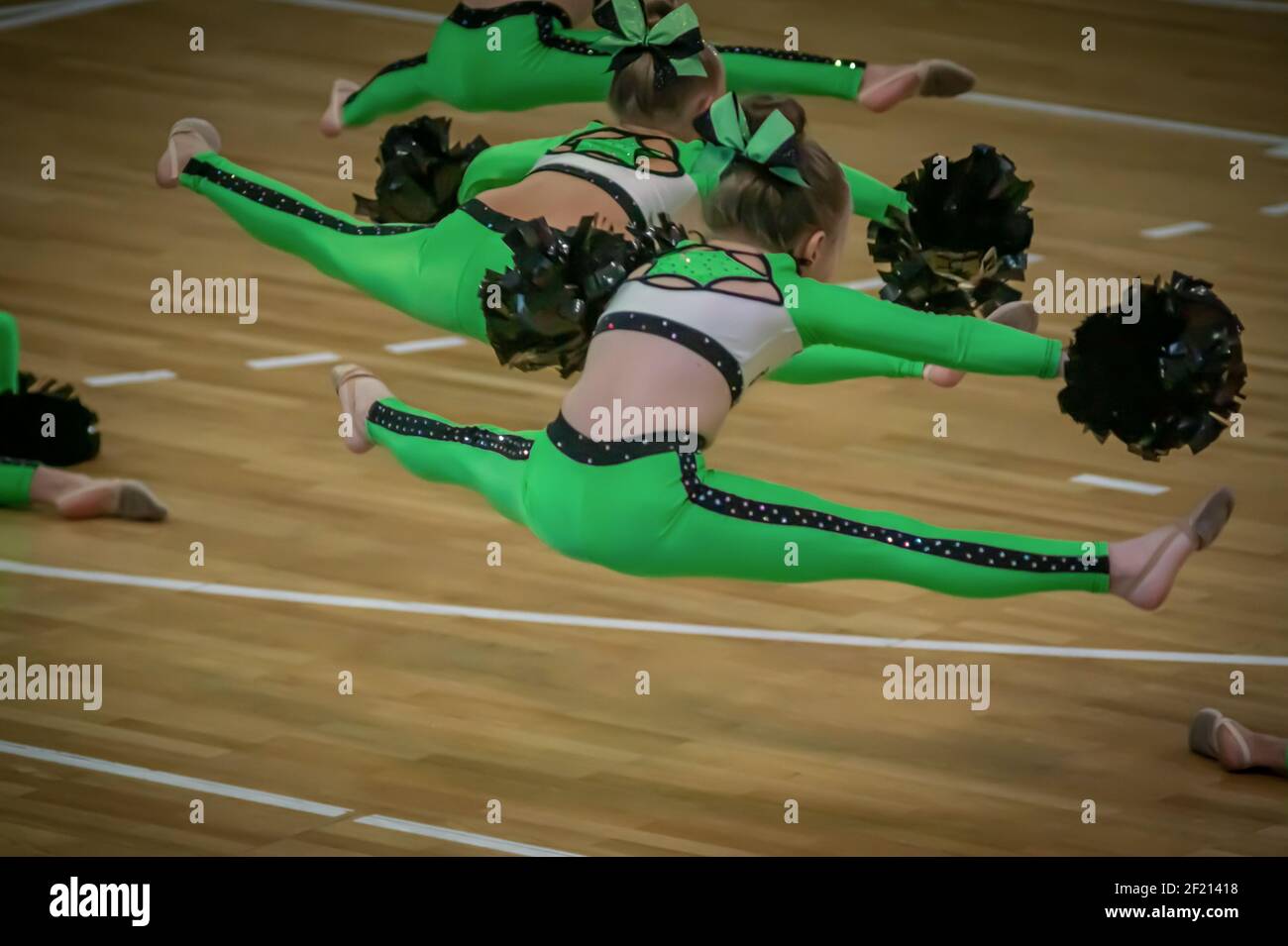 Young girls doing jump splits at a charleading competition Stock Photo ...