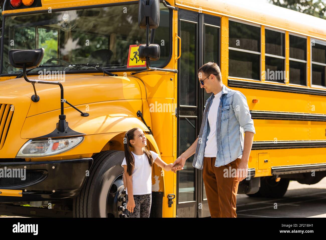 Girl with father going back to school near the school bus Stock Photo ...