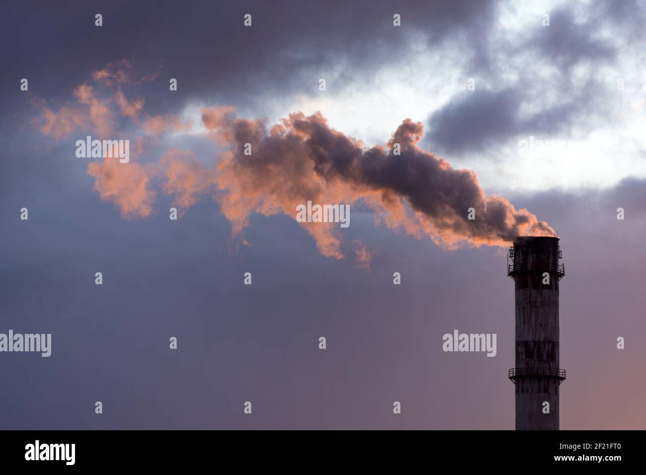 Industrial smoke from chimney on dramatic sundown sky. Factory pipe ...
