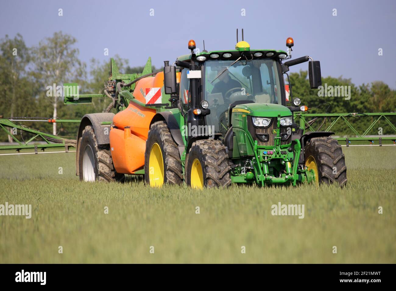 Farmer drives his tractor with crop protection sprayer over his wheat ...