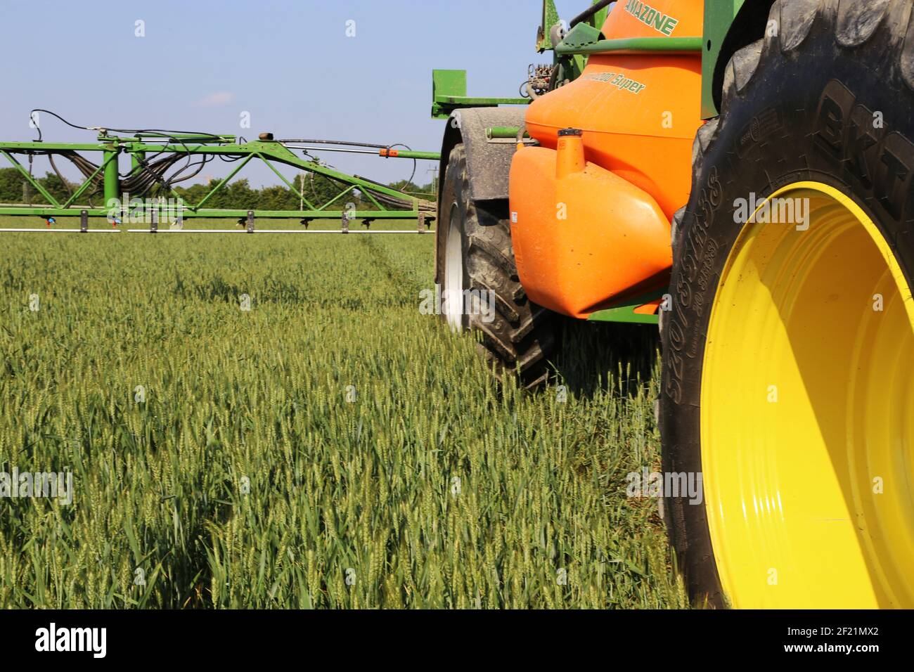 Farmer drives his tractor with crop protection sprayer over his wheat ...