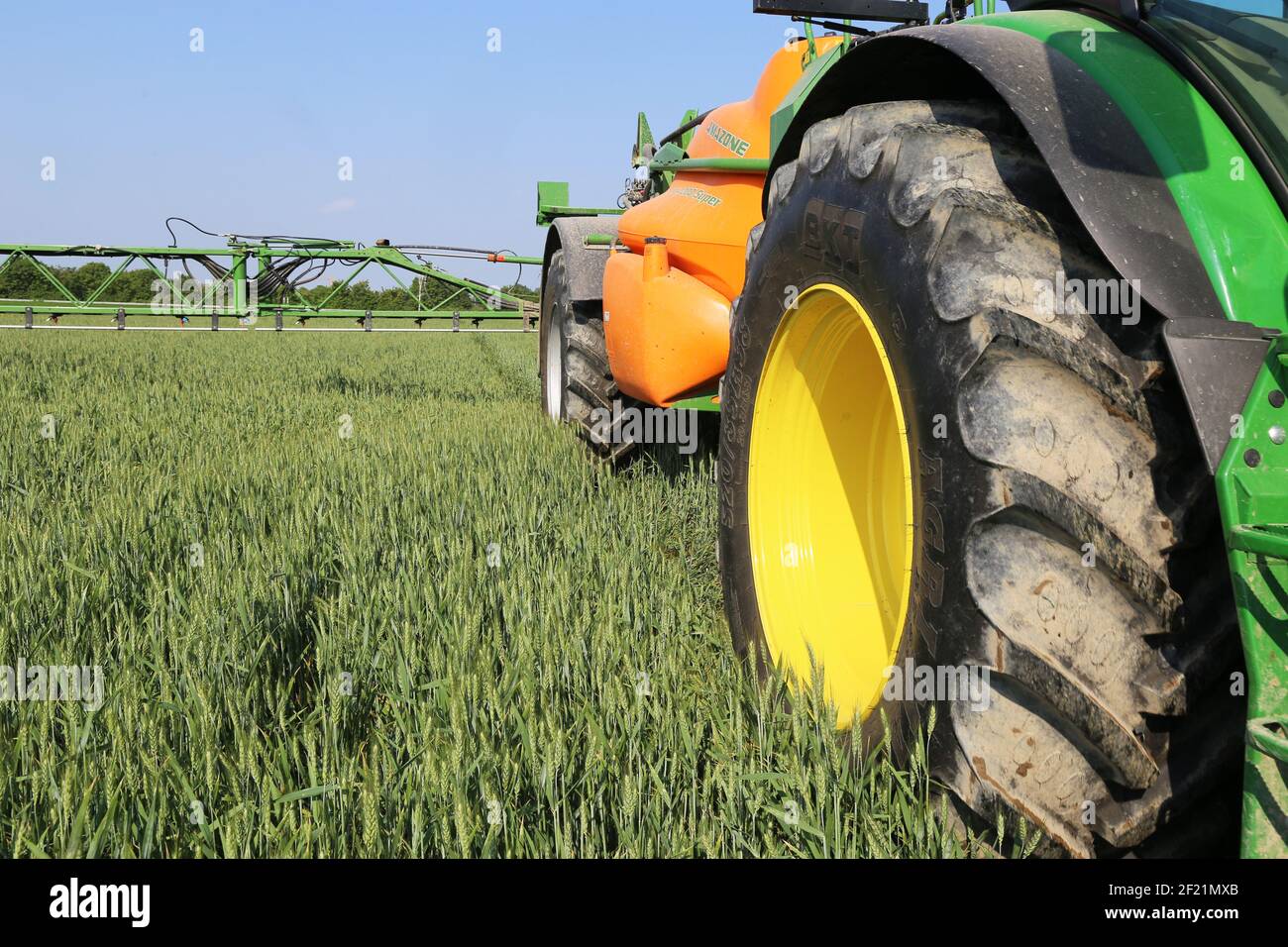 Farmer drives his tractor with crop protection sprayer over his wheat ...