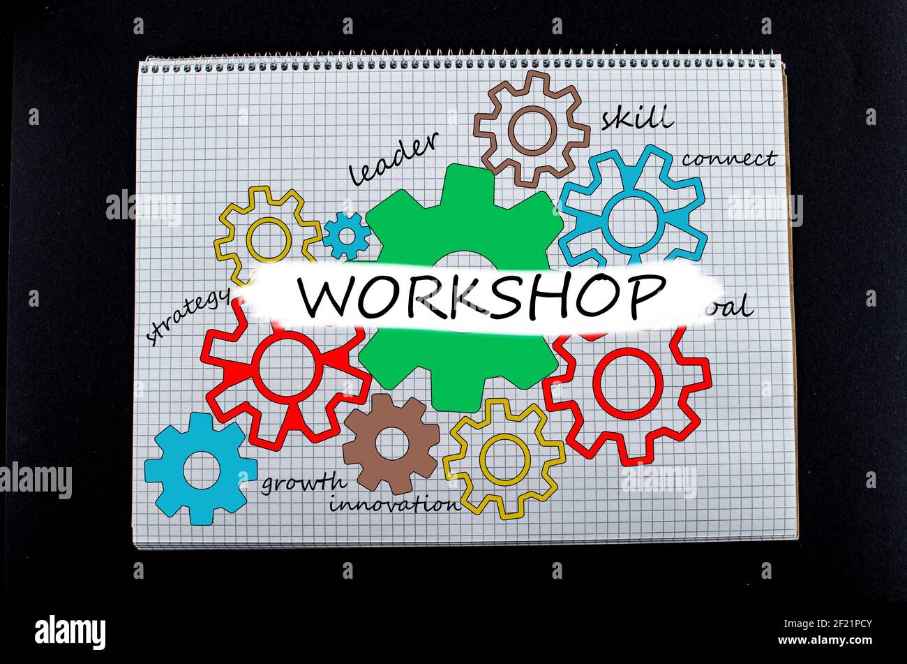 Workshop concept. View of colorful drawing of gears in notepad with ...