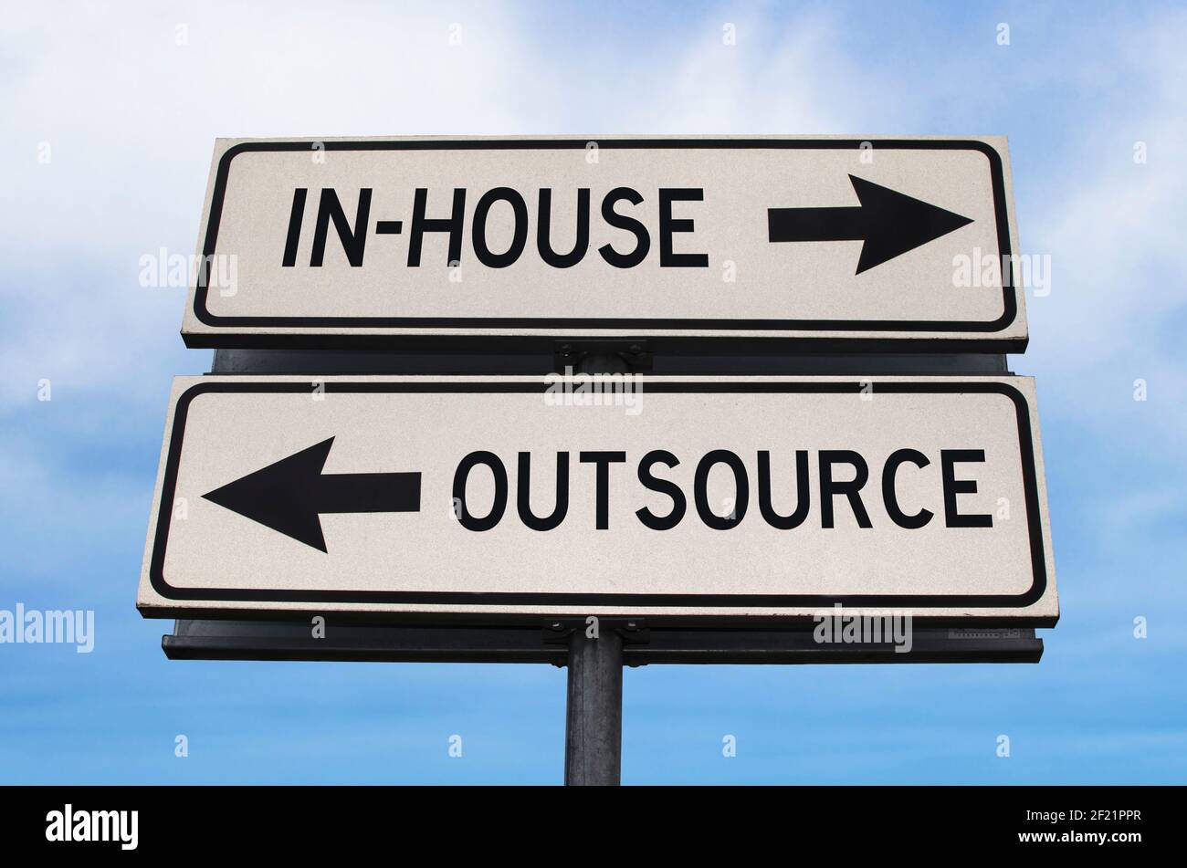 Outsource versus in-house road sign with two arrows on blue sky ...