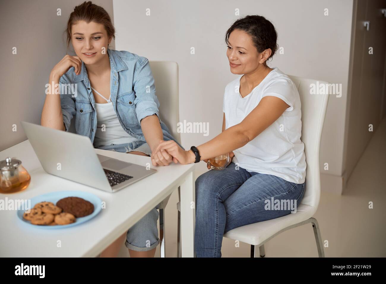 Happy two young females watching film together Stock Photo - Alamy