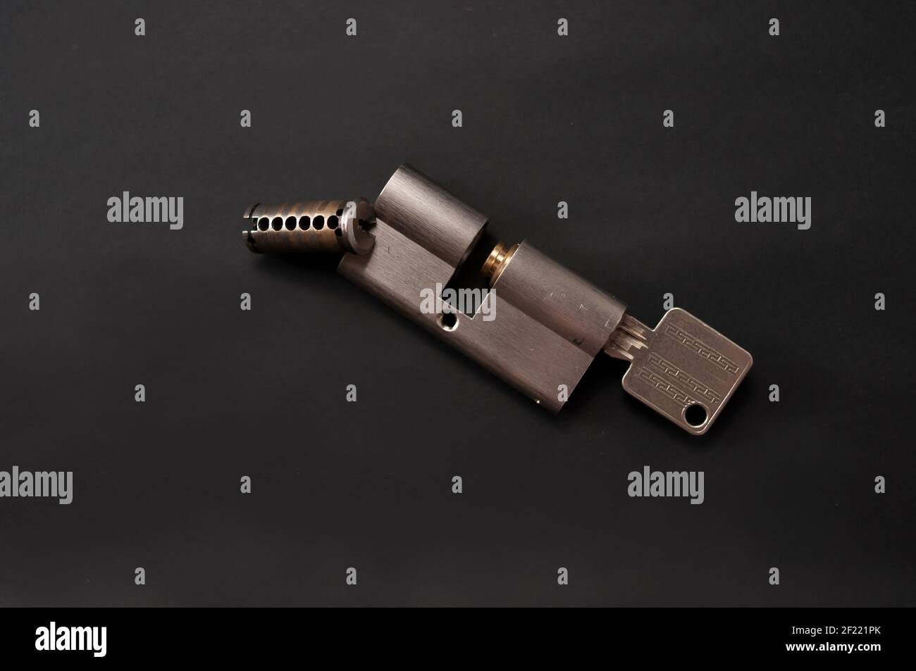 Cylinder lock with removed core and inserted key on black background ...