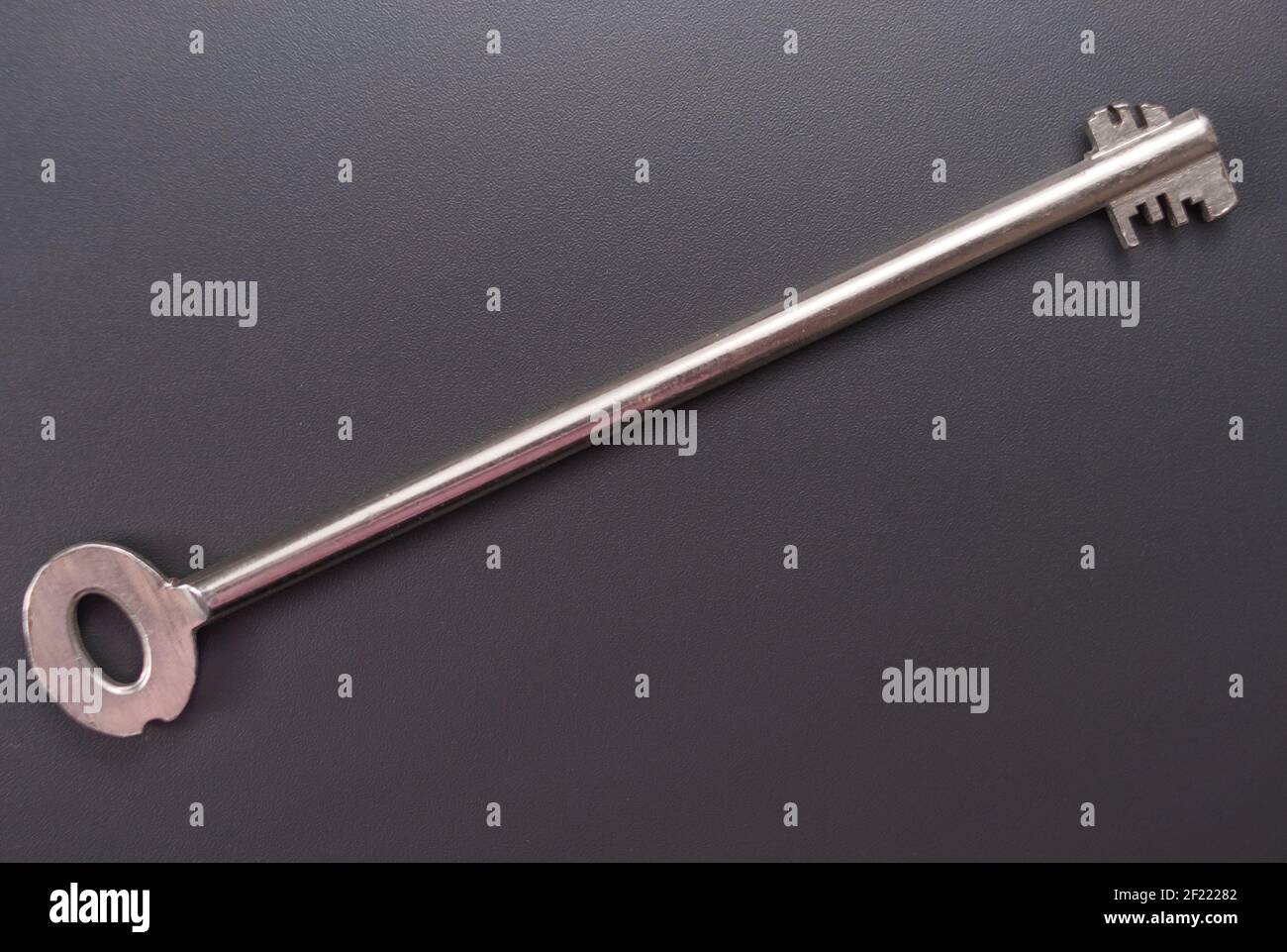 A safe key, safe key in an extra long design. The background is black ...