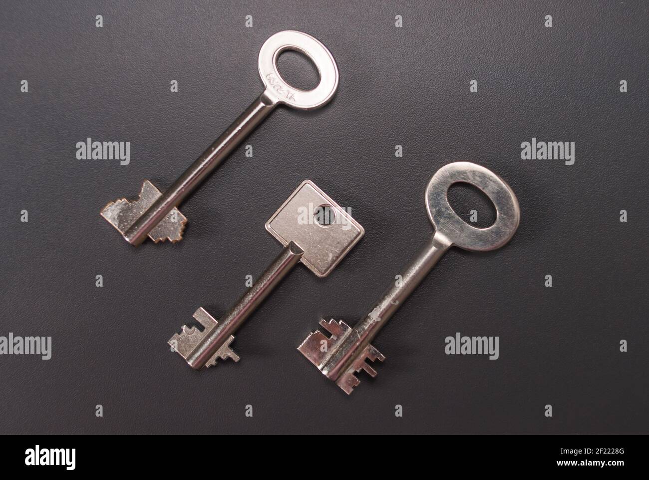 Still life with three safes keys in different designs on a black ...