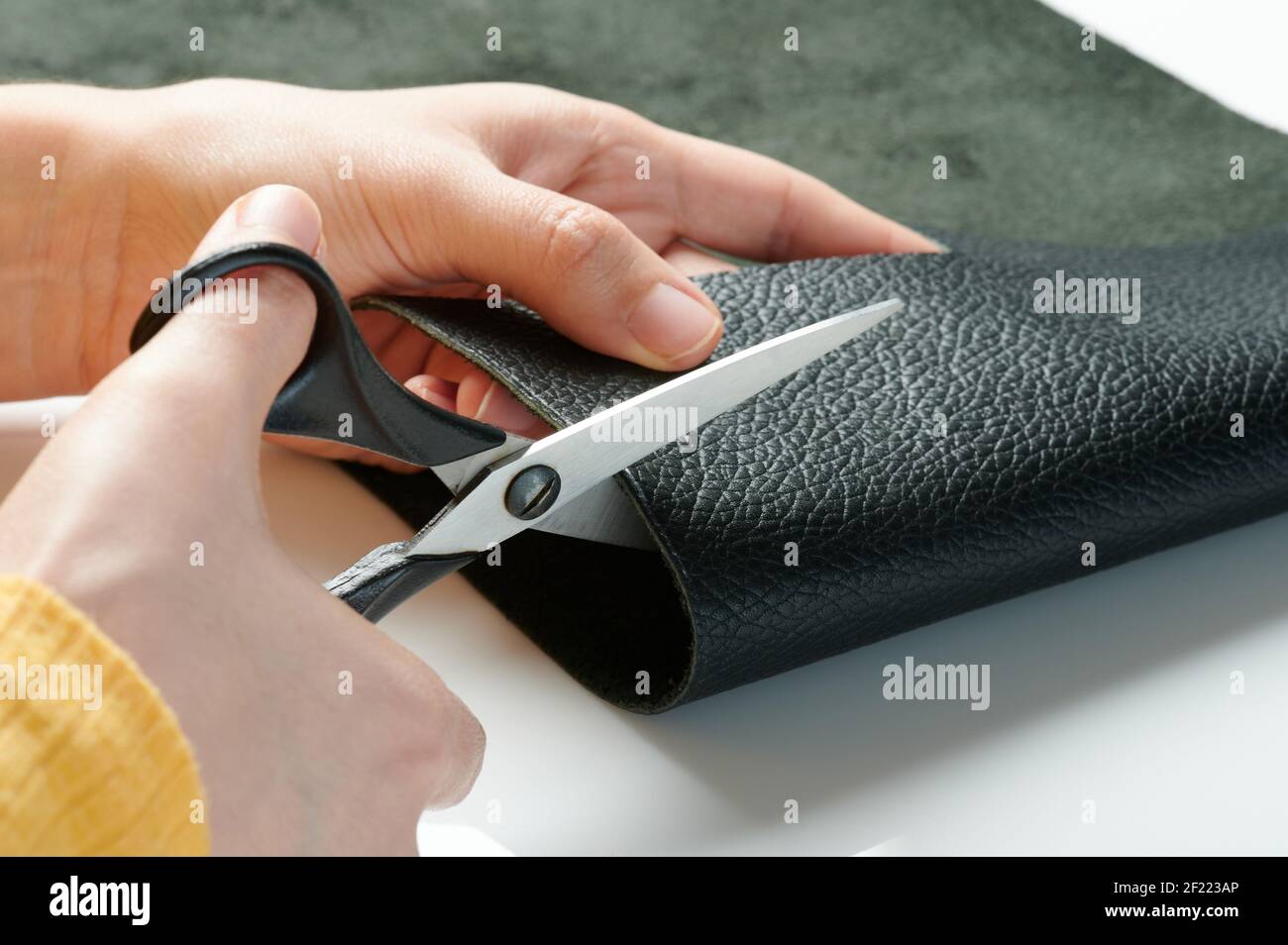 Cutting black leather with scissors macro close up view Stock Photo - Alamy