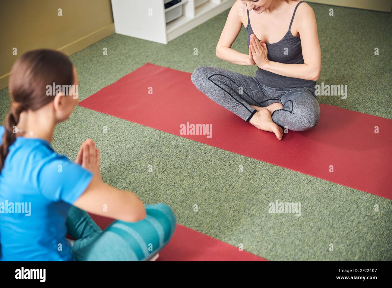 Two women doing namaste greeting to each other Stock Photo - Alamy