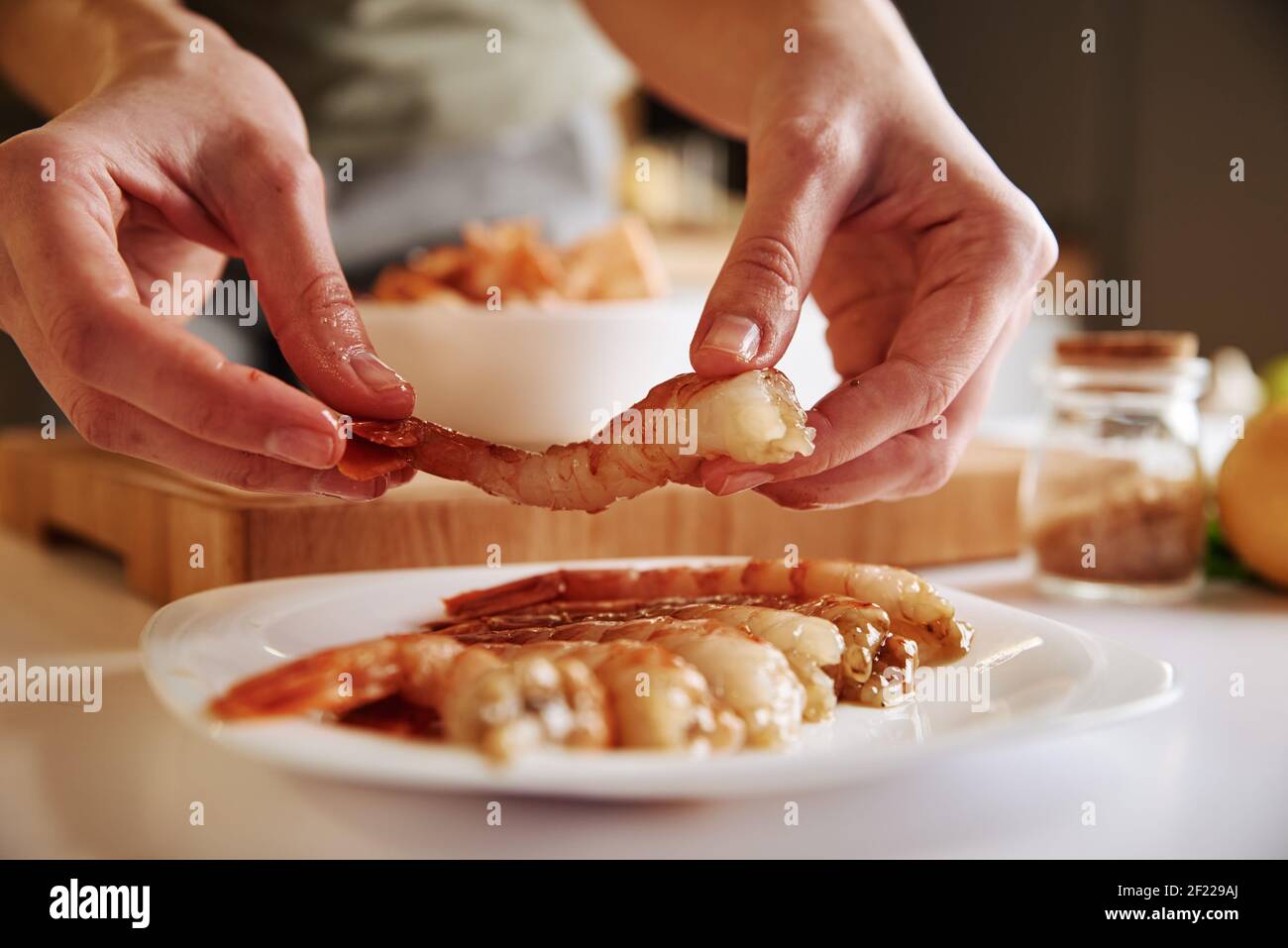 Woman take fresh raw shrimp from a plate. Cooking prawns Stock Photo ...