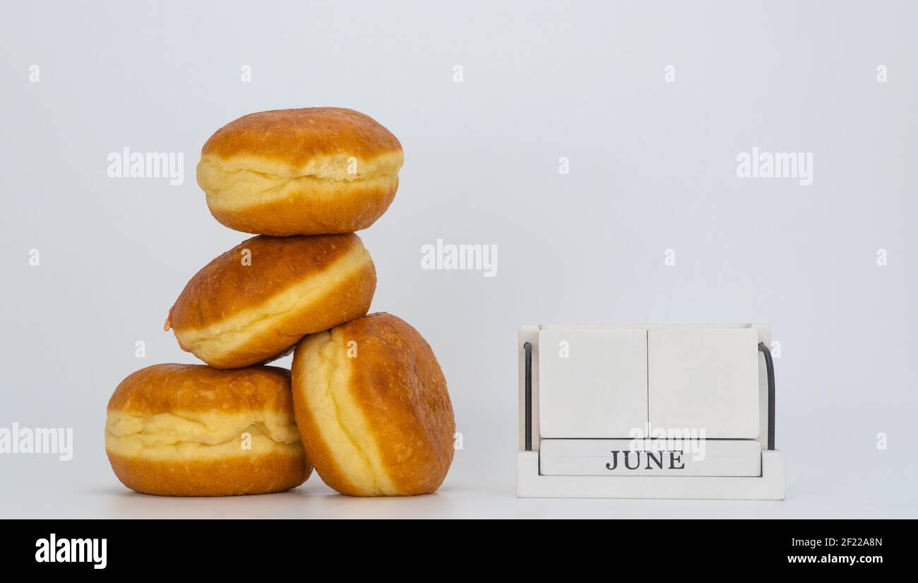 wooden calendar and delicious doughnuts. National Donut Day, holiday ...