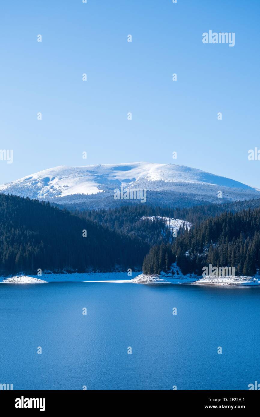 Shot at Lake Oașa in Romania, on a cold winter day with bright blue ...