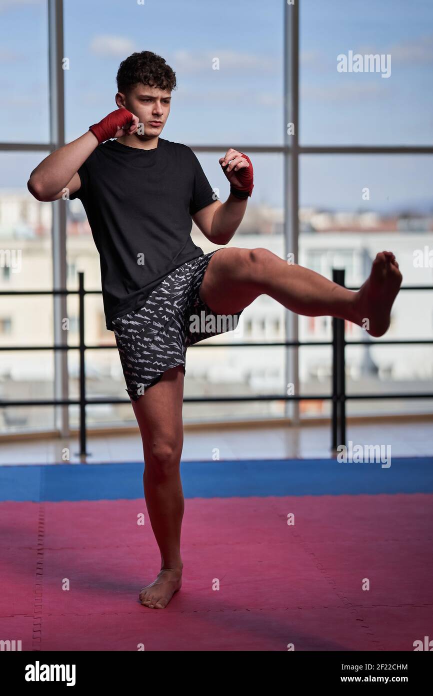Young kickboxer with hands wrapped doing shadow boxing in the gym Stock ...