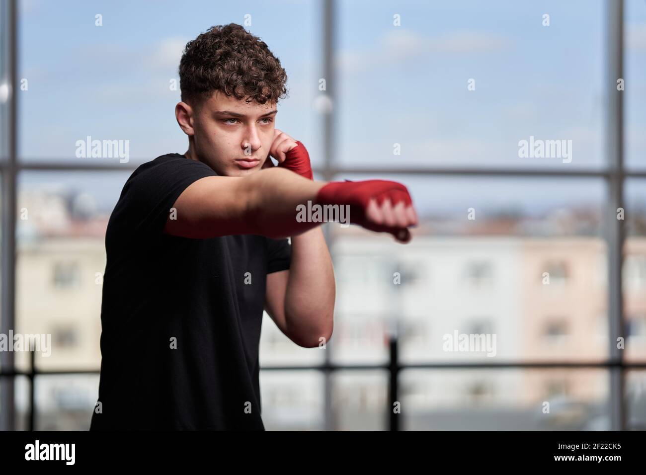 Young kickboxer with hands wrapped doing shadow boxing in the gym Stock ...