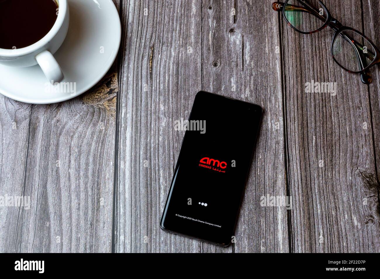 A mobile phone or cell phone laid on a wooden table with the AMC ...