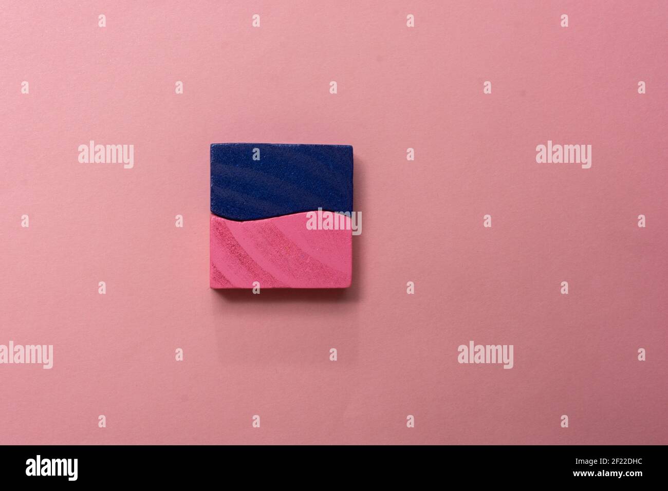 A high angle shot of blue and pink wooden blocks on pink background ...