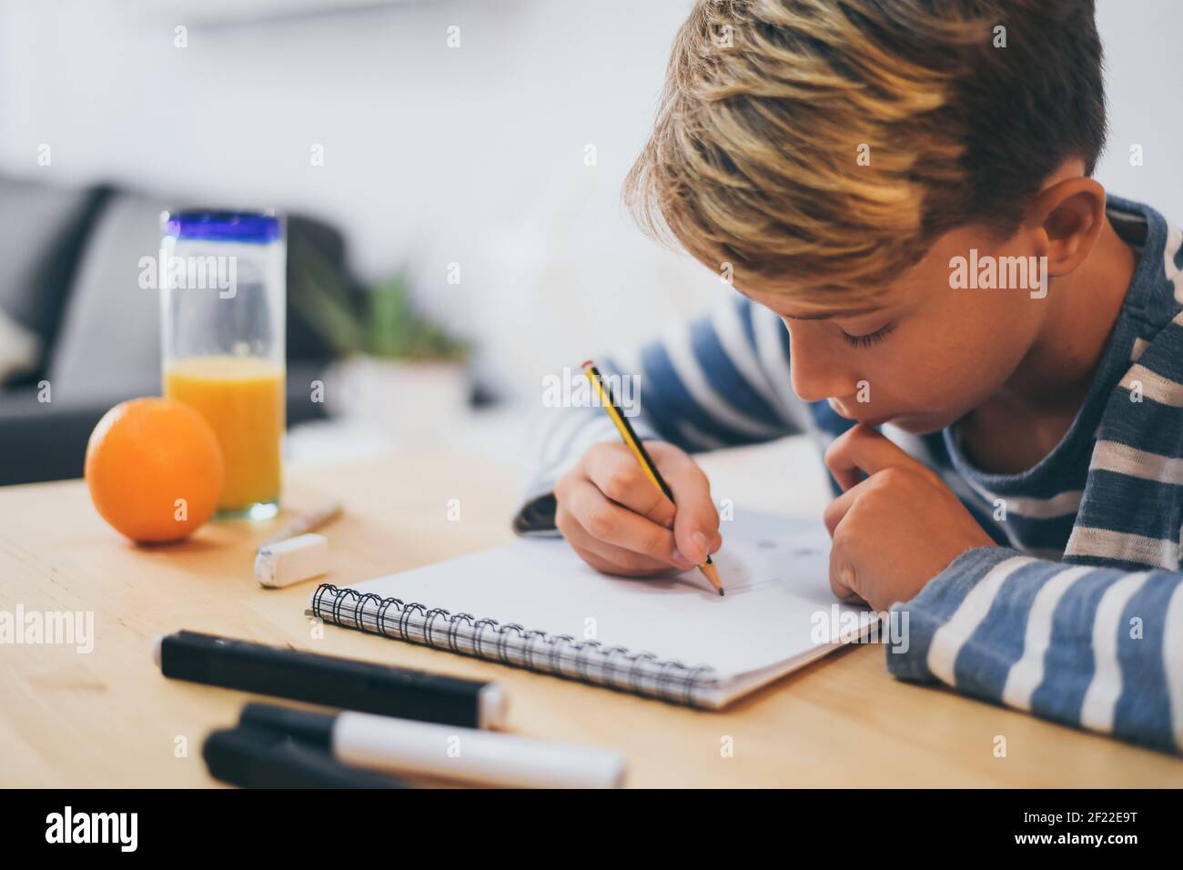 Student drawing with pencil on the notebook. Boy doing homework writing ...