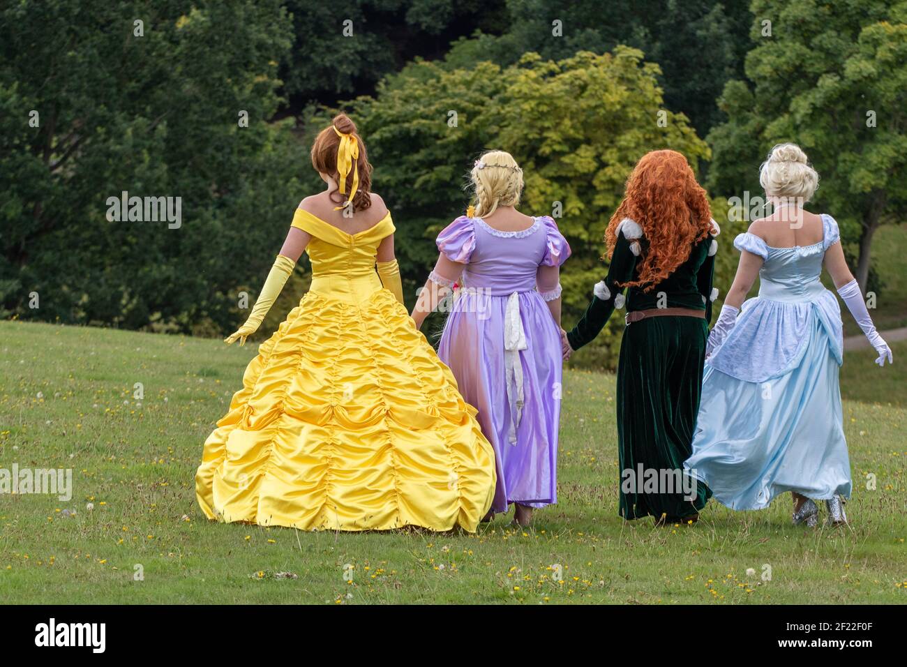 Group of Disney princess dressed women at a charity event walk away ...