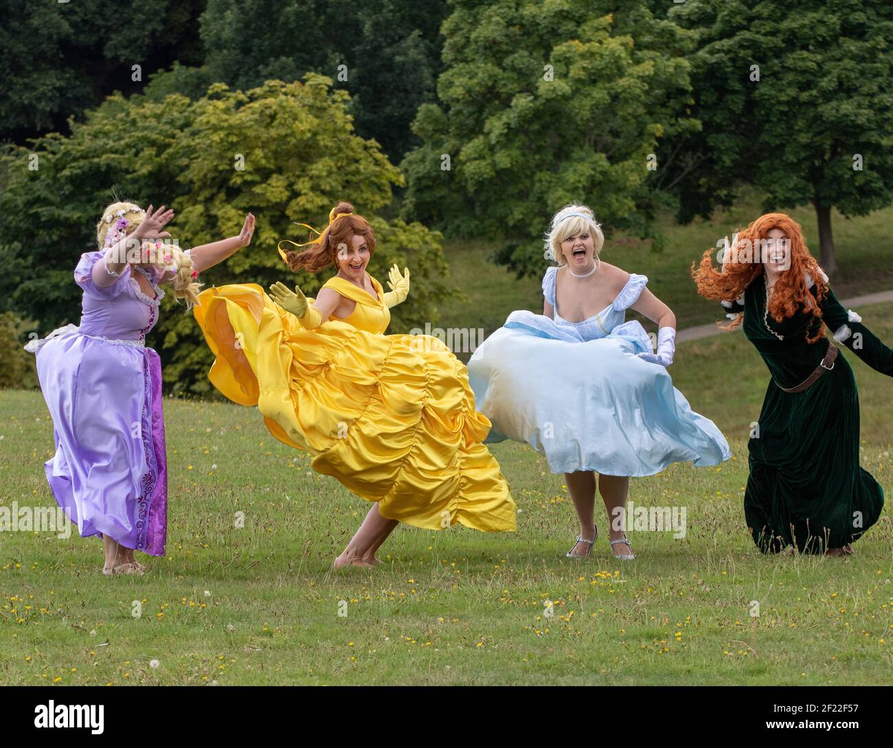 Four Disney princesses at a charity event jump in the air and wave ...
