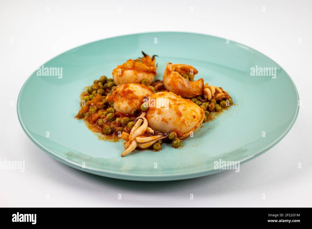 second course with cuttlefish and tomato peas on a white background ...