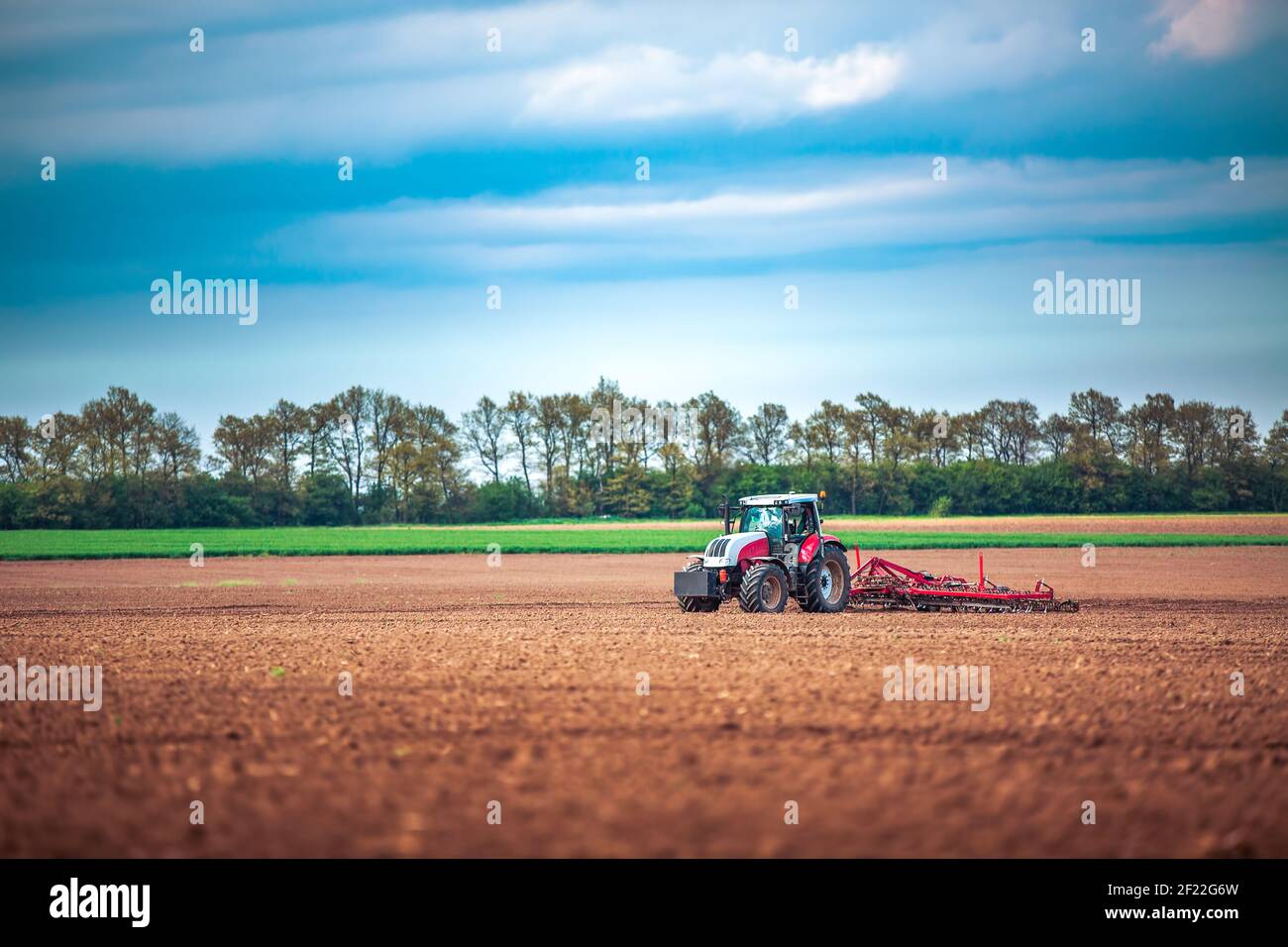 Farmer in tractor preparing land with seedbed cultivator Stock Photo ...
