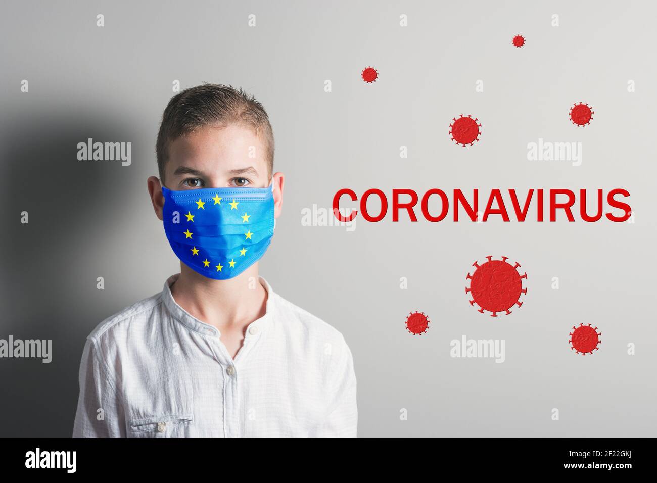 Boy in a medical mask with flag of European Union on his face on bright ...