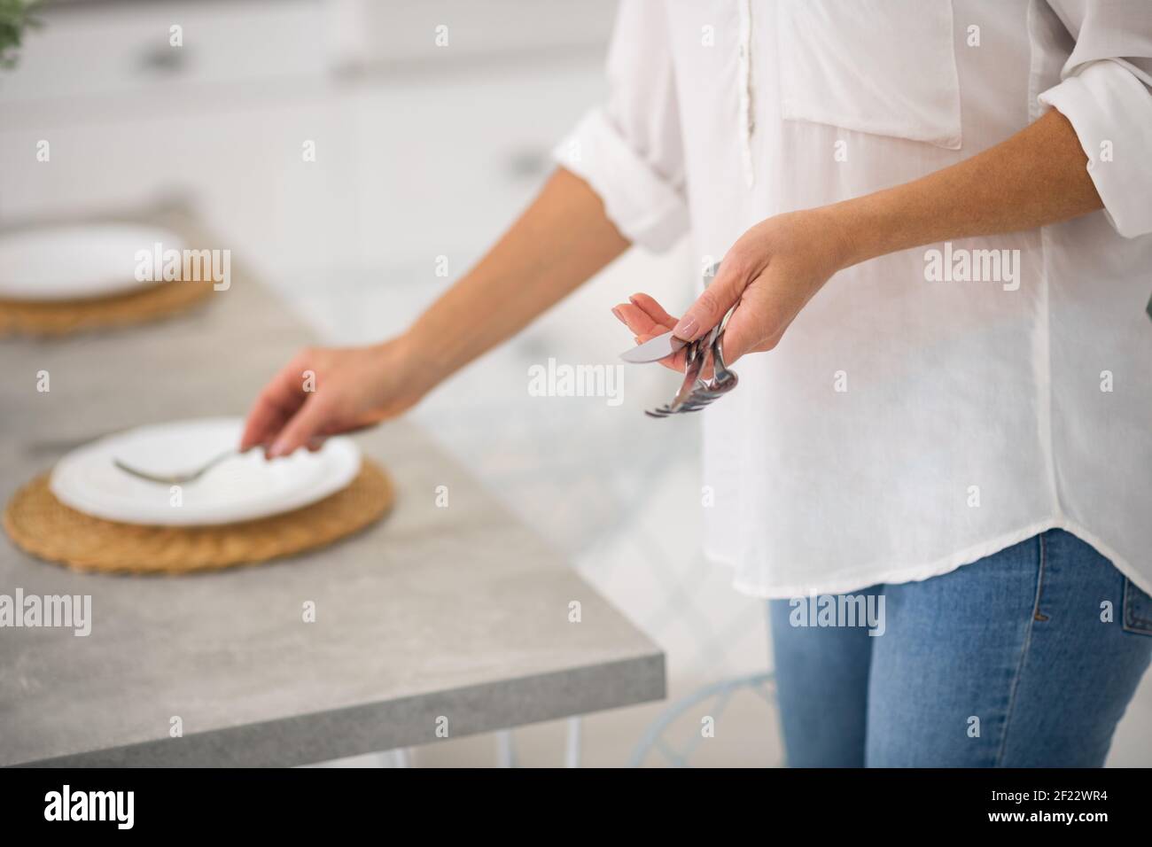 Close up of womans hands serving the table for dinner Stock Photo - Alamy