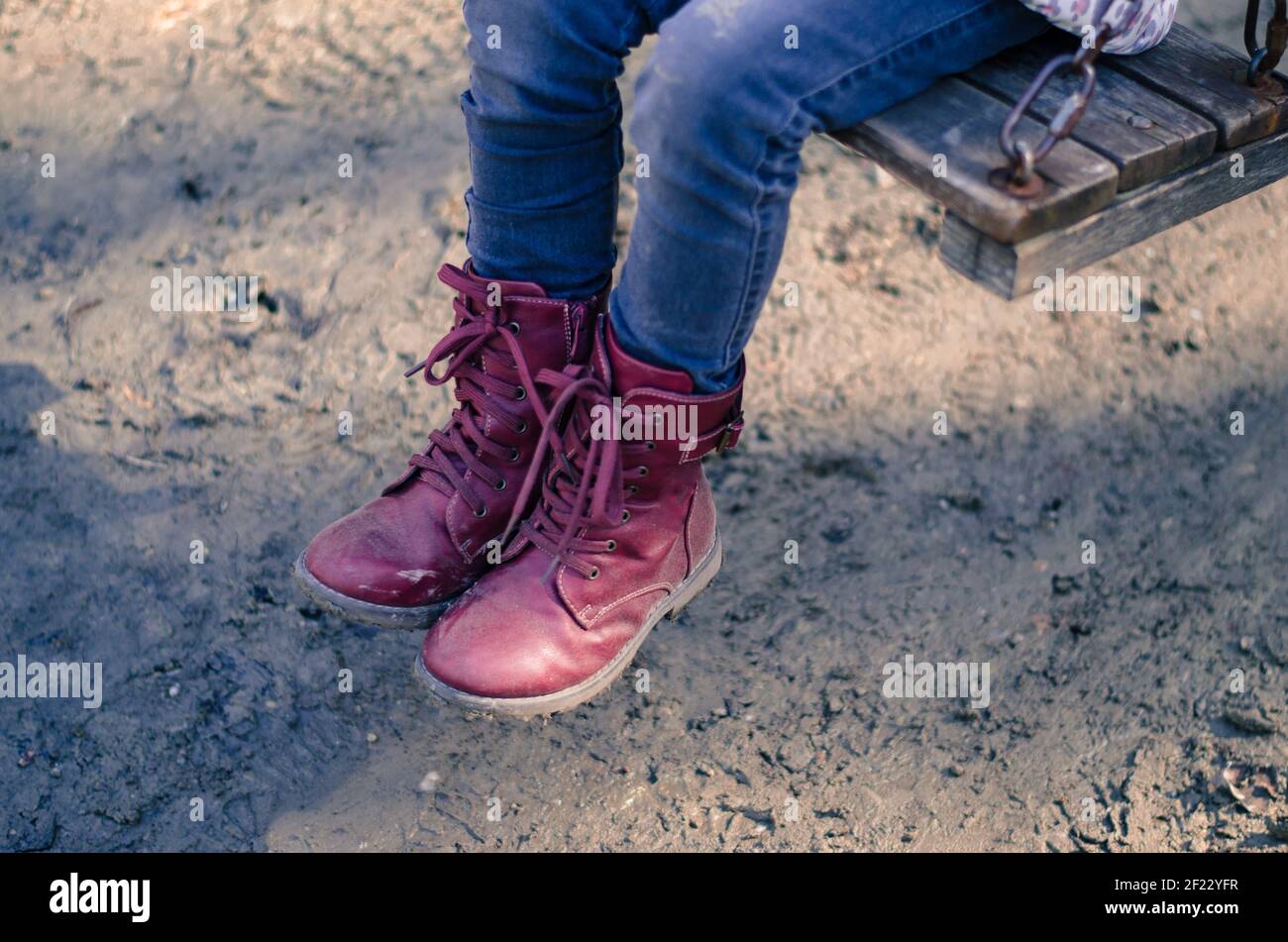 faceless child with red shoes and jeans sitting in swing Stock Photo ...