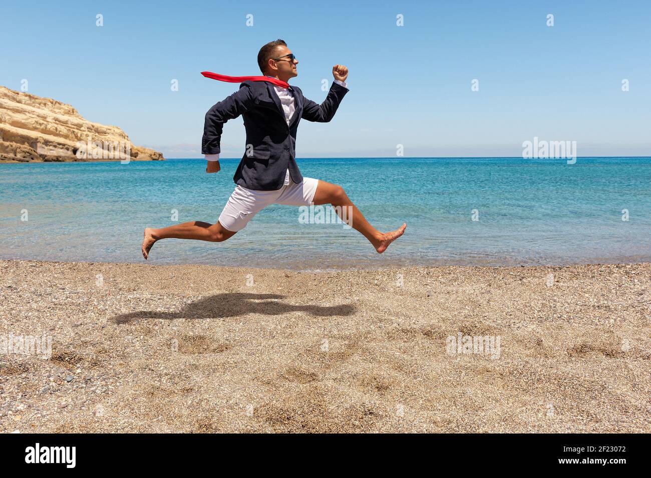 Happy businessman running away from office work on the beach. Summer ...