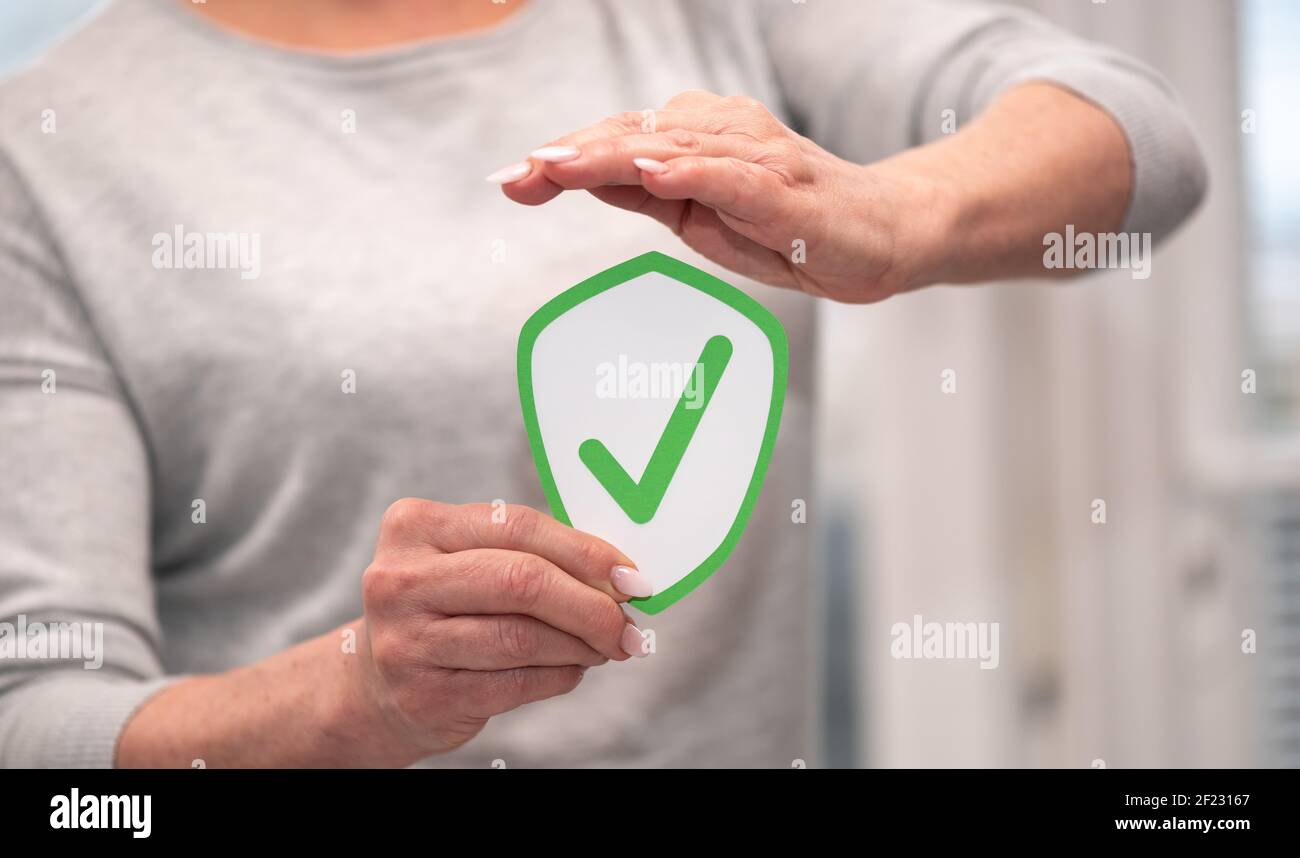 Concept of approved protection system with paper shield held by female ...