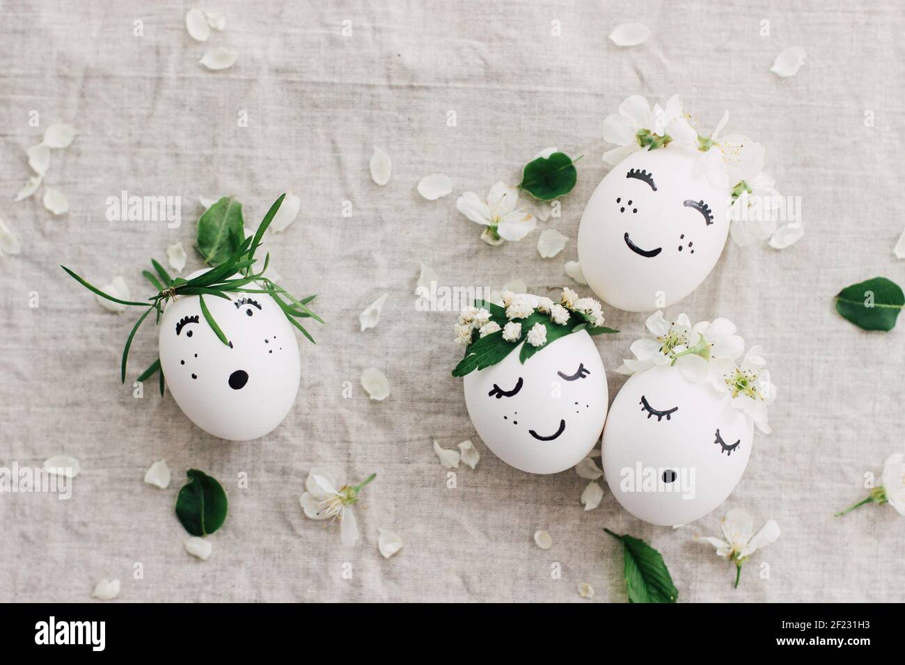 Happy Easter! Natural eggs with drawn funny faces in cute floral crowns ...