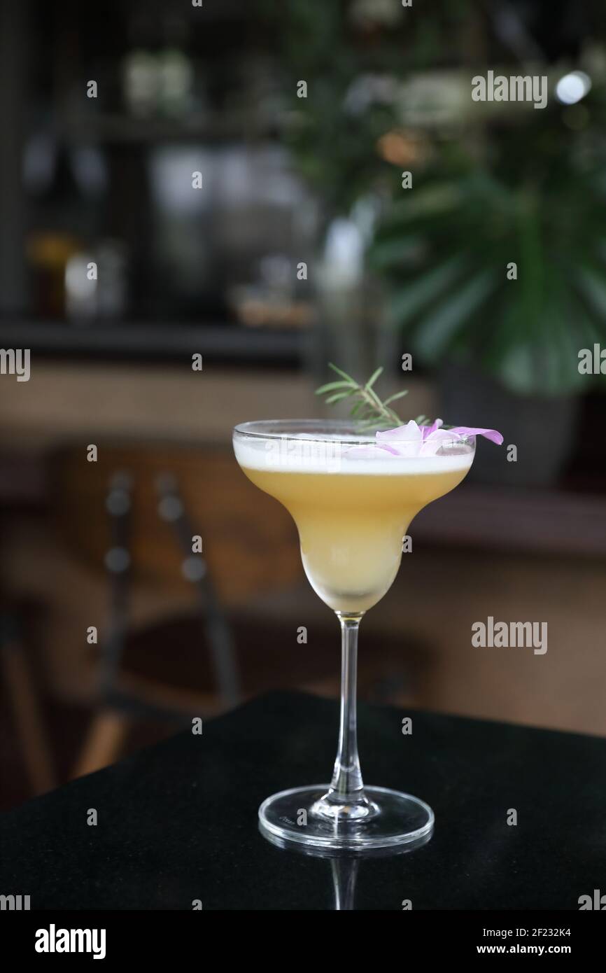 Yellow Cocktail glass with ice at a bar counter Stock Photo - Alamy