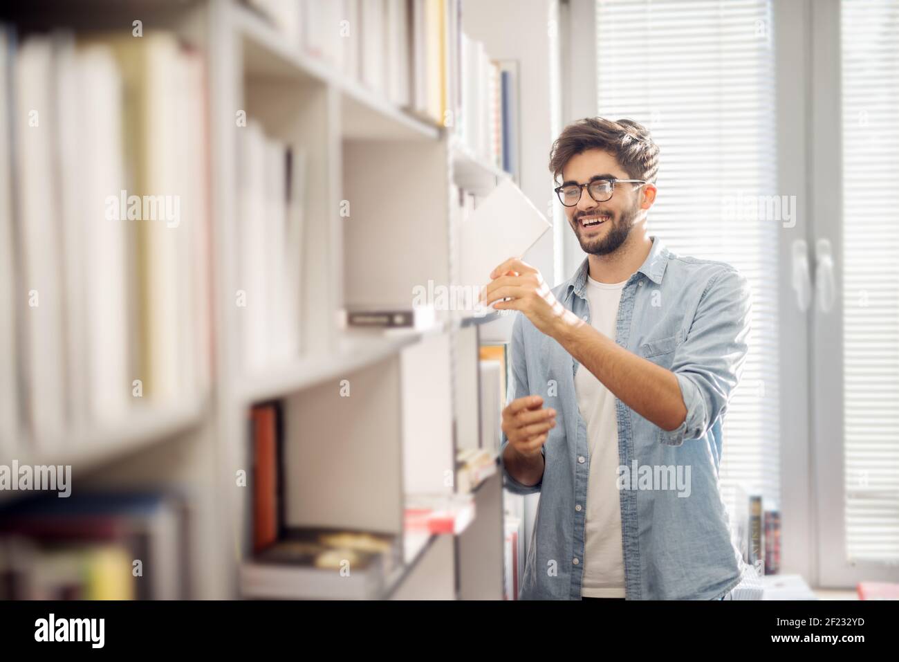 Man taking a book from shelf hi-res stock photography and images - Alamy