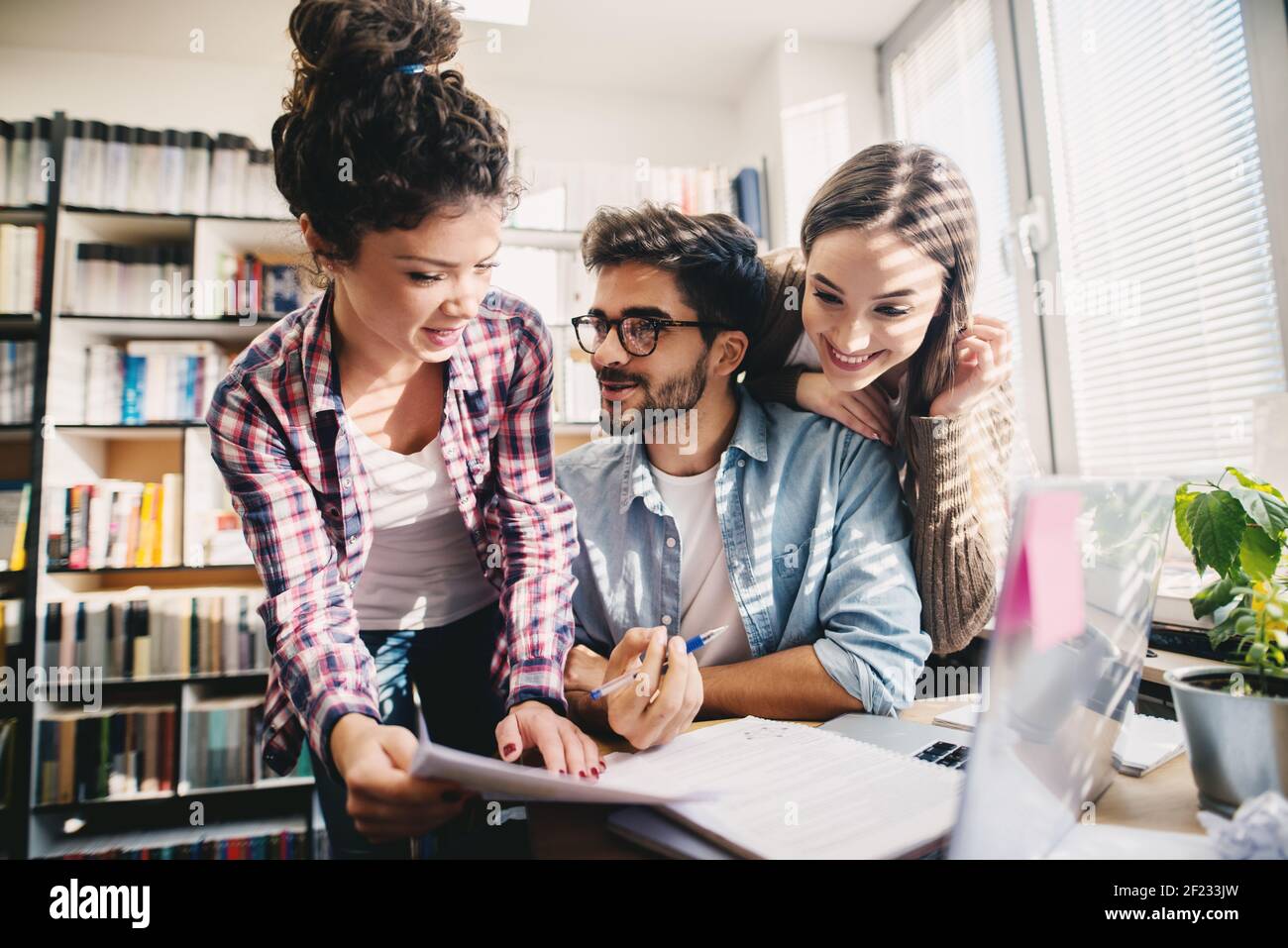 Group of pretty cheerful students preparing project together at the ...