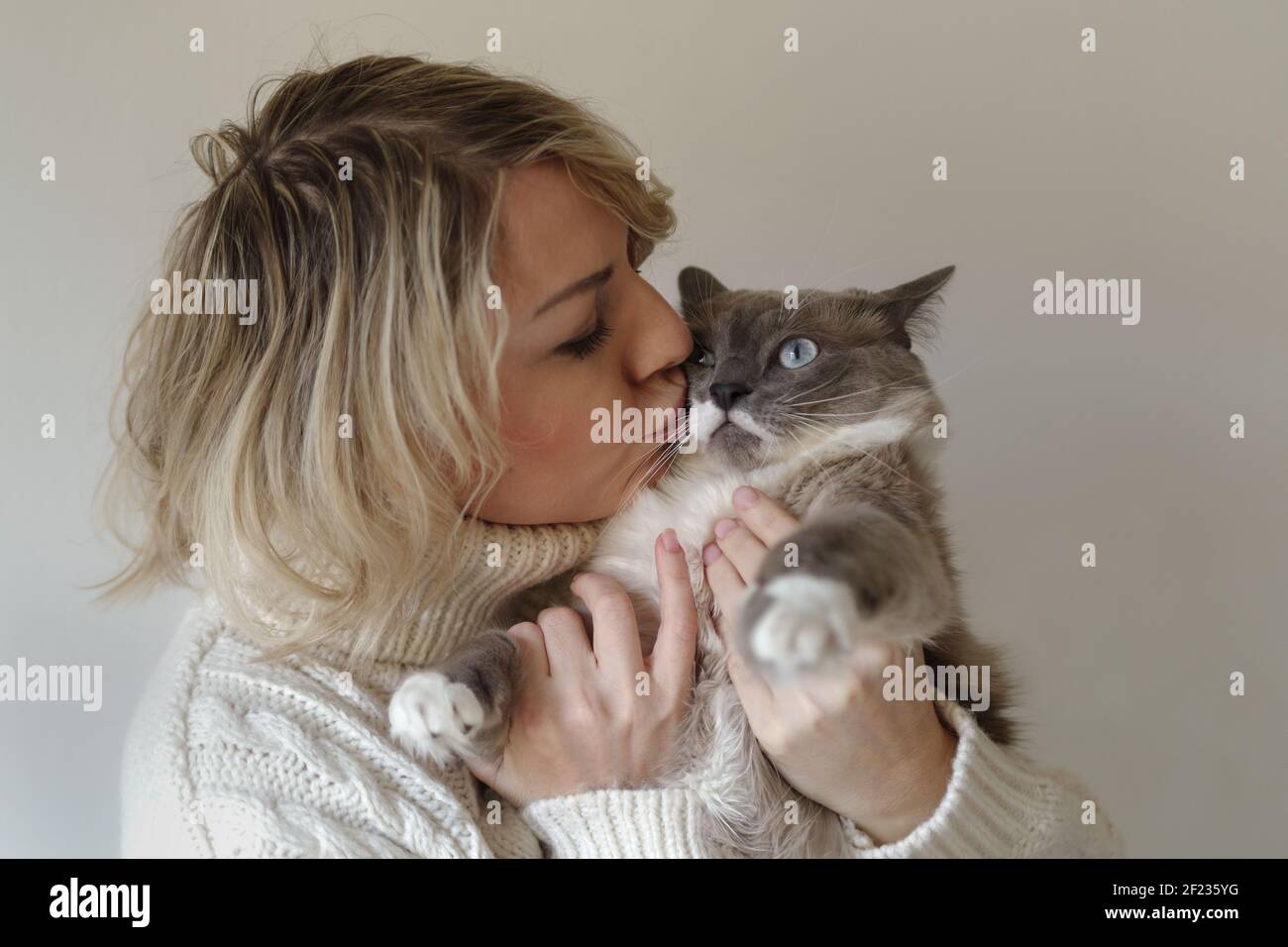 Close up of a woman hugging her Siamese cat indoor Stock Photo - Alamy