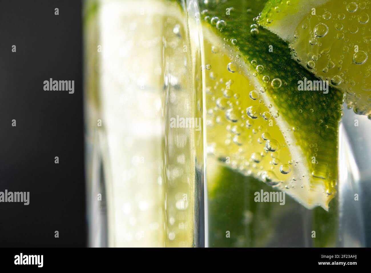 Lime slice with a drops in fizzy sparkling water. Summer drink concept ...
